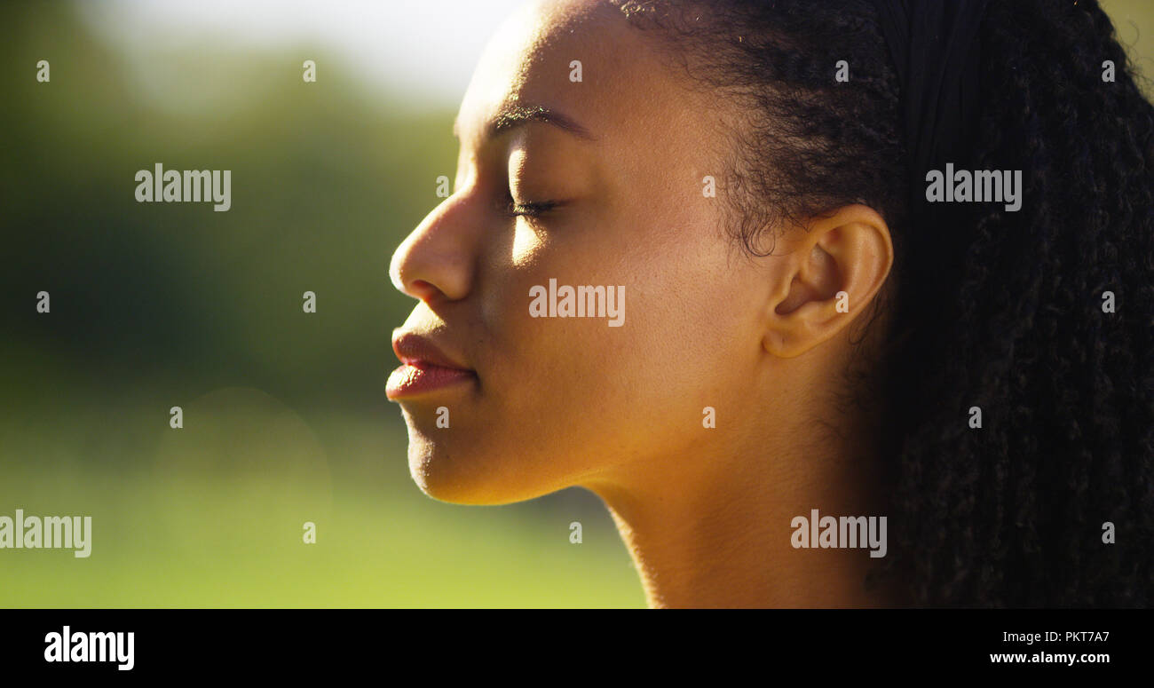 Beautiful black woman feeling the sun on her face Stock Photo - Alamy