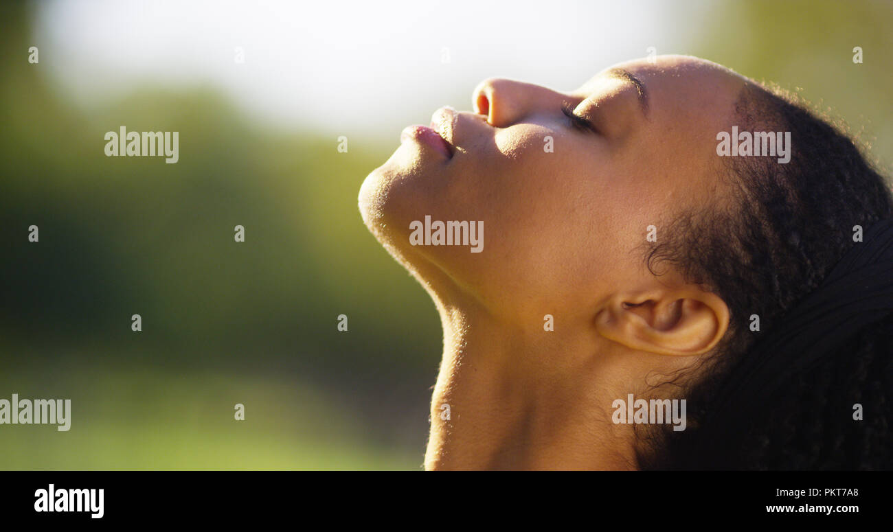 Beautiful black woman feeling the sun on her face Stock Photo - Alamy