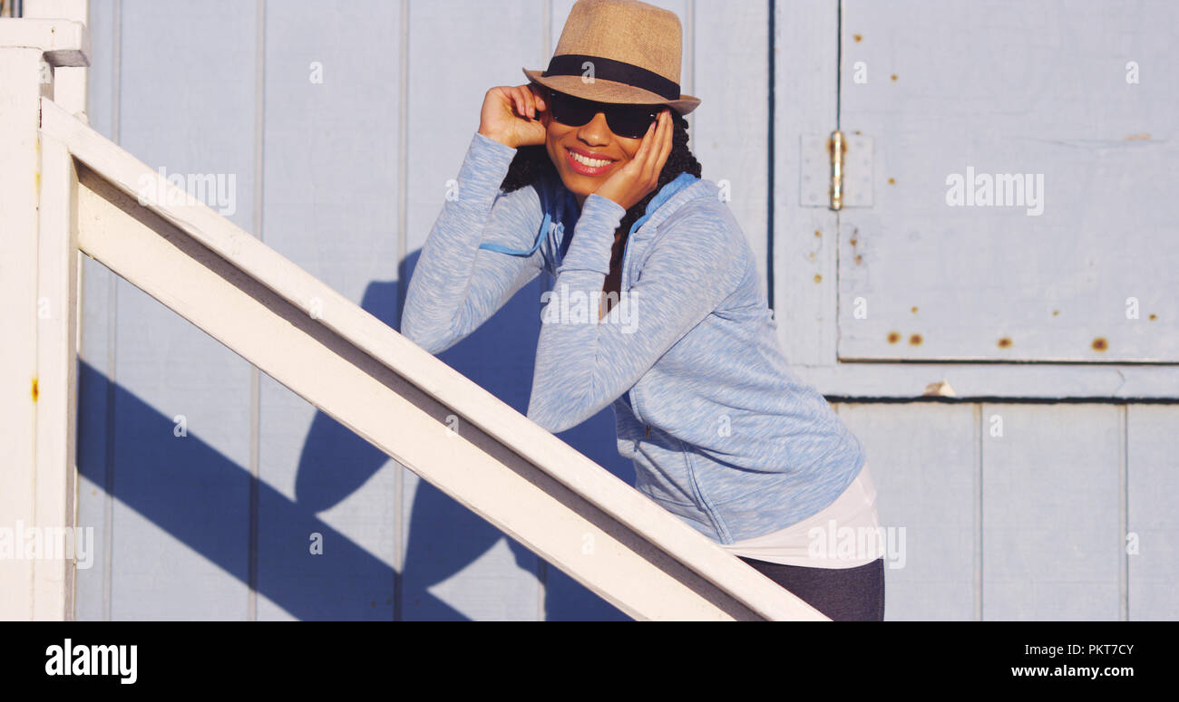 Happy Black woman leaning on wooden rail Stock Photo - Alamy