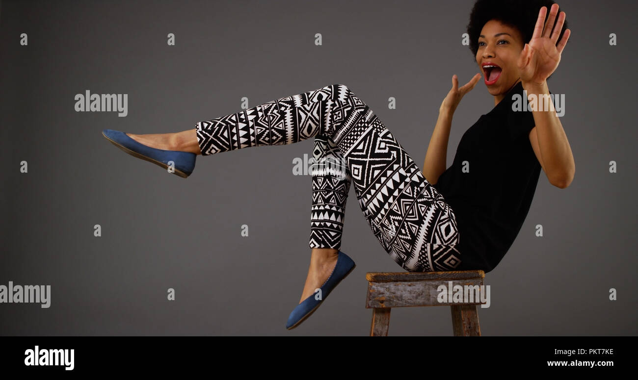 Black woman dancing on chair Stock Photo - Alamy