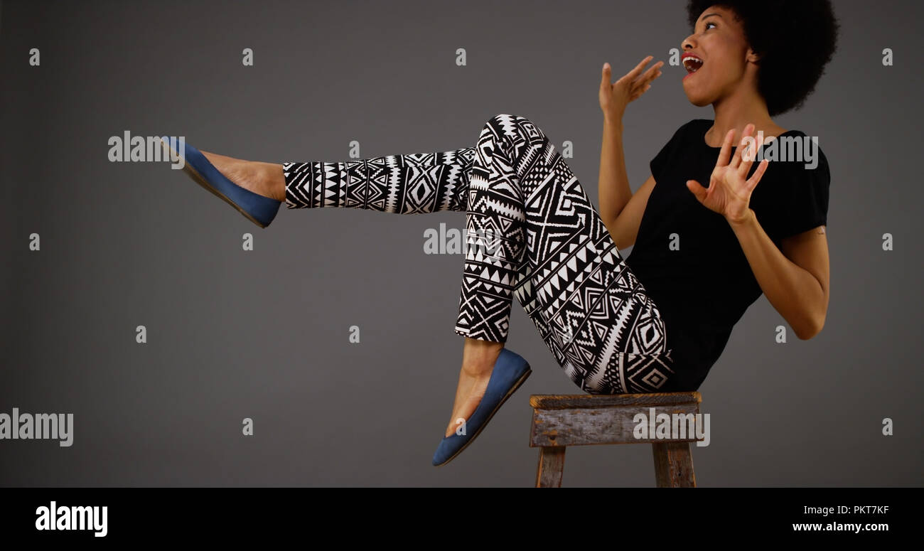 Black woman dancing on chair Stock Photo - Alamy