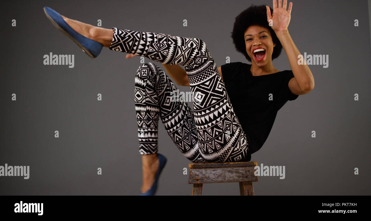 Fun black woman dancing on chair Stock Photo - Alamy