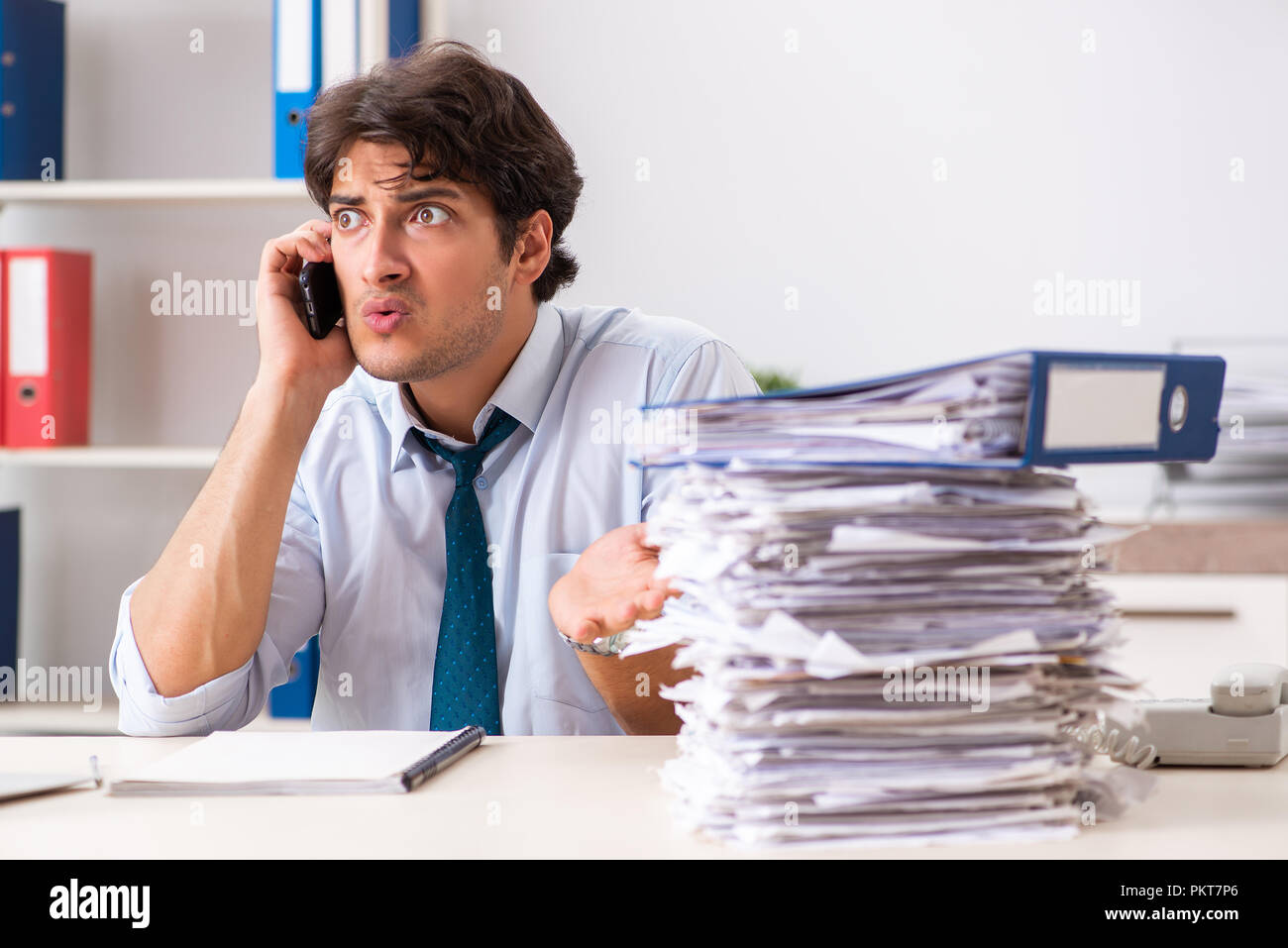 Overloaded busy employee with too much work and paperwork Stock Photo ...