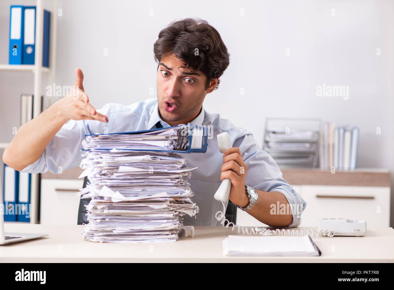 Overloaded busy employee with too much work and paperwork Stock Photo ...