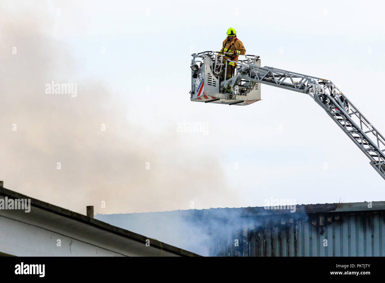 English fireman on top of extended ladder platform spotting outbreaks ...