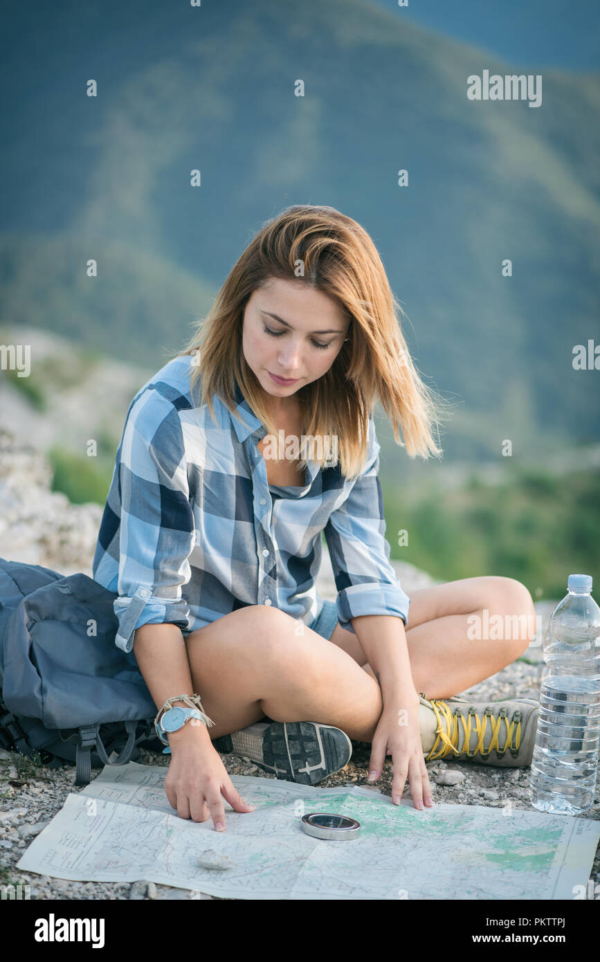 Young woman reading map in mountain Stock Photo - Alamy
