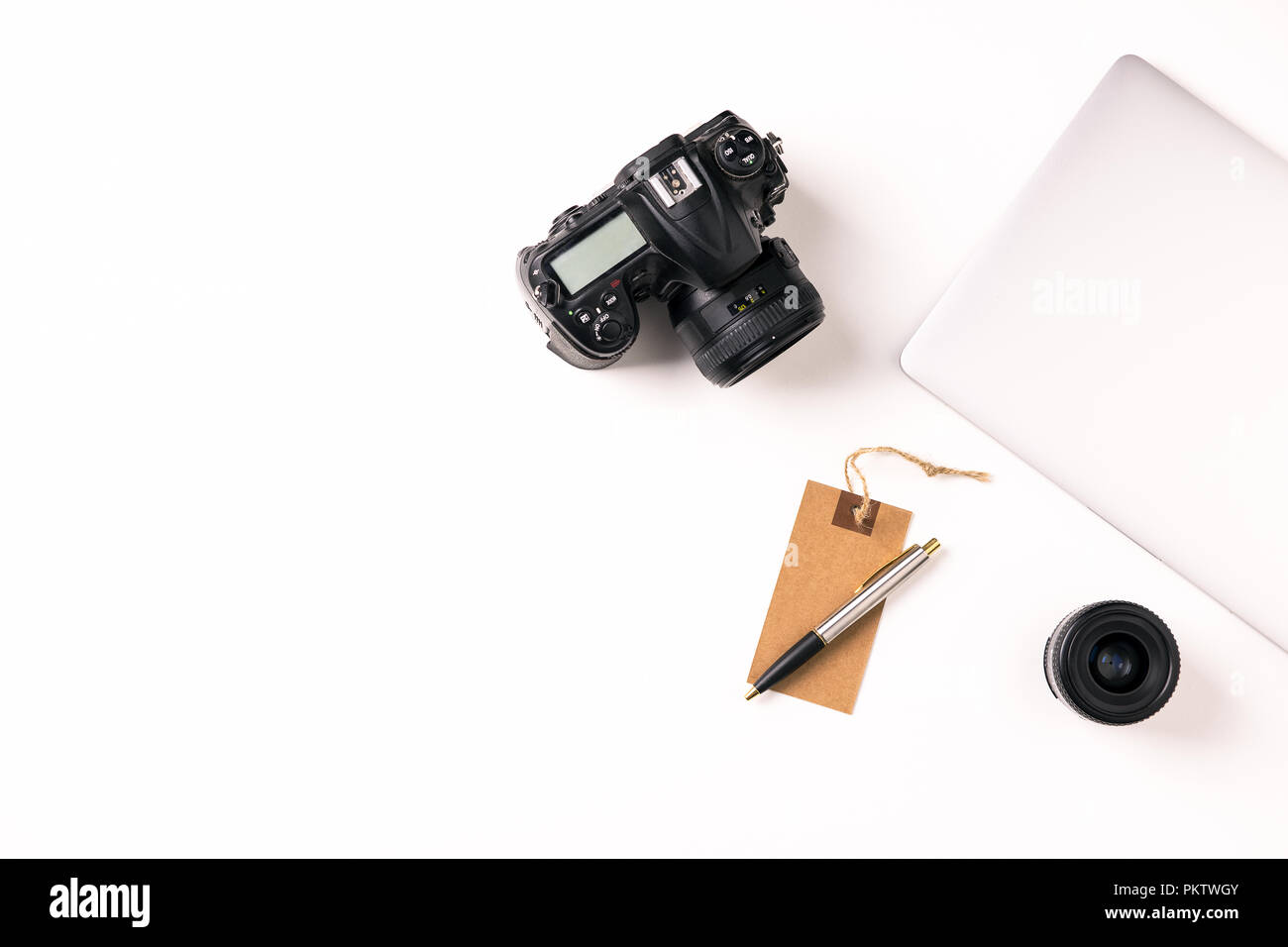 Station photographer with notebook, camera and lenses on white desk ...