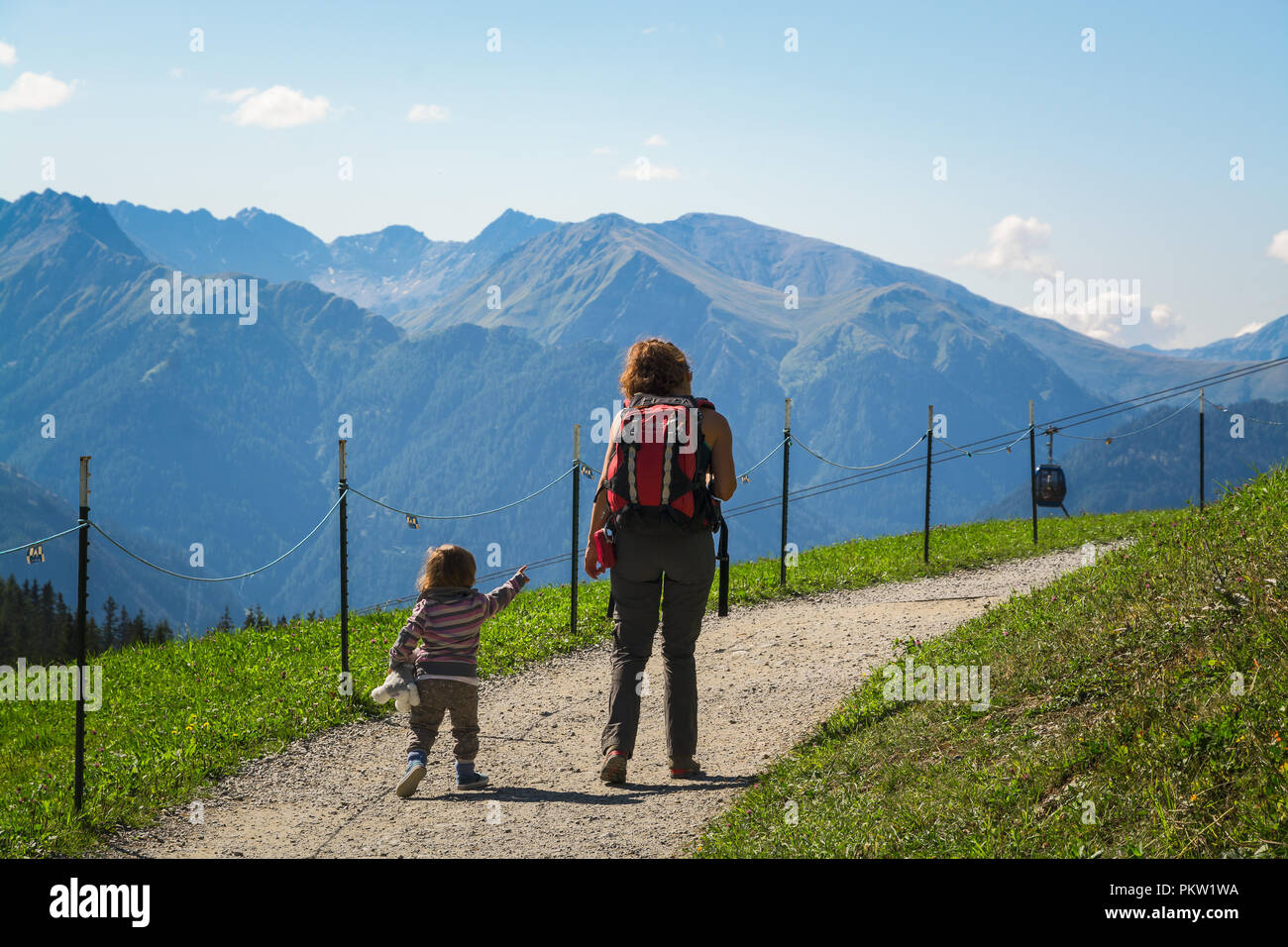 Mother and little child trekking on mountains, child pointing to a ...