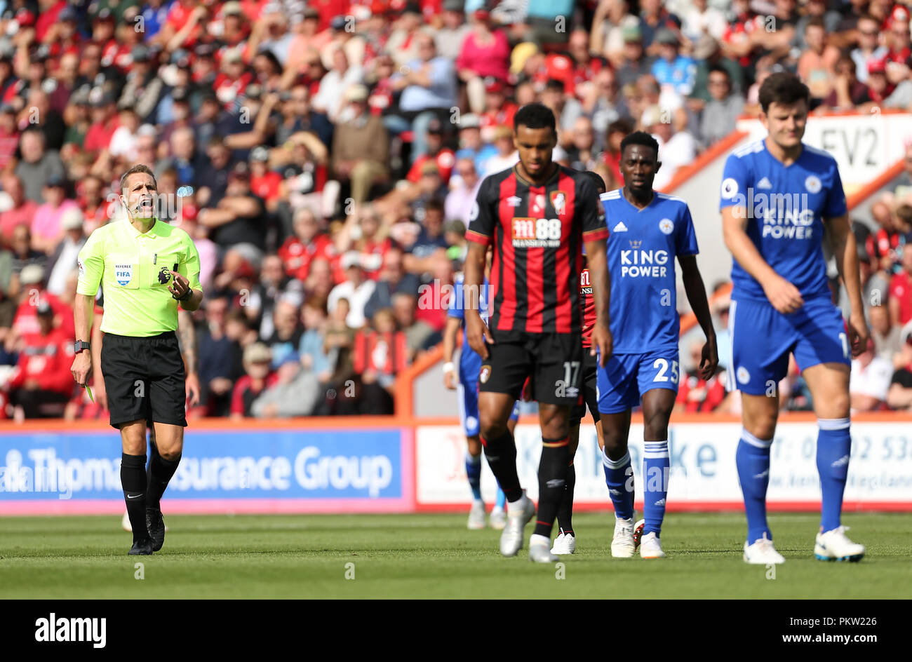 Leicester City's Harry Maguire (right) is shown a yellow card by match referee Craig Pawson ...
