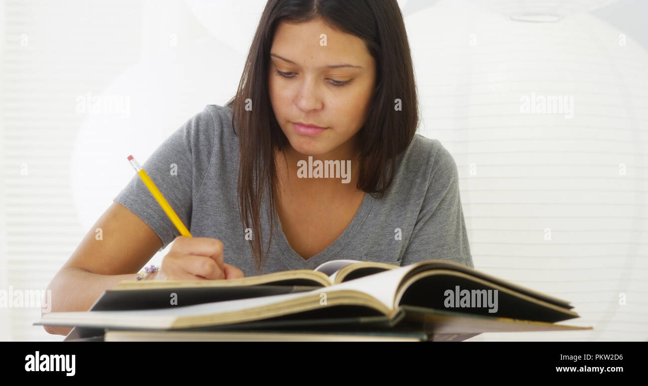 Young Hispanic woman doing research on desk Stock Photo - Alamy
