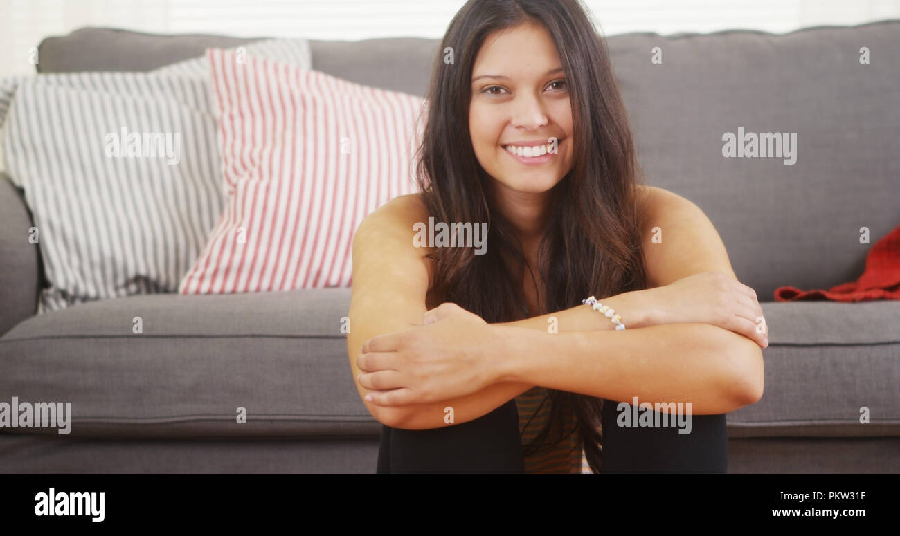 Cute woman sitting in living room laughing and smiling Stock Photo - Alamy