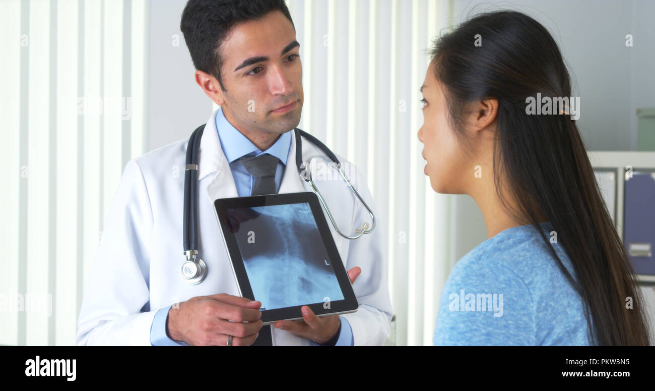 Mexican doctor talking with Chinese patient about xray Stock Photo - Alamy