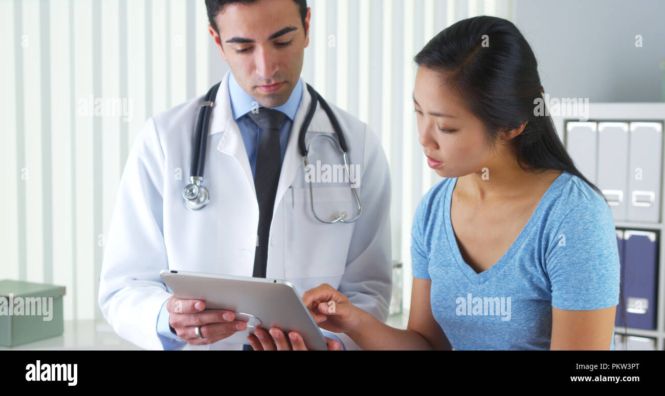 Hispanic doctor talking with patient with test results on tablet Stock ...