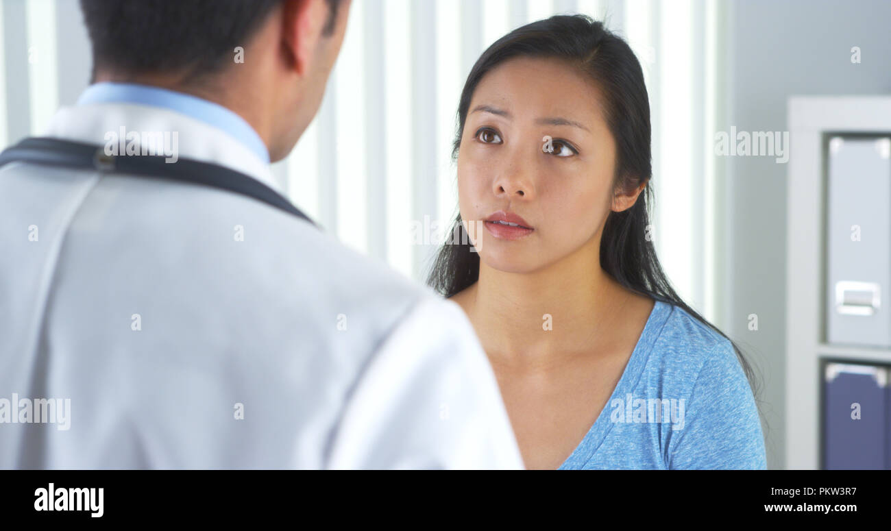 Chinese patient talking to doctor about neck pain Stock Photo - Alamy