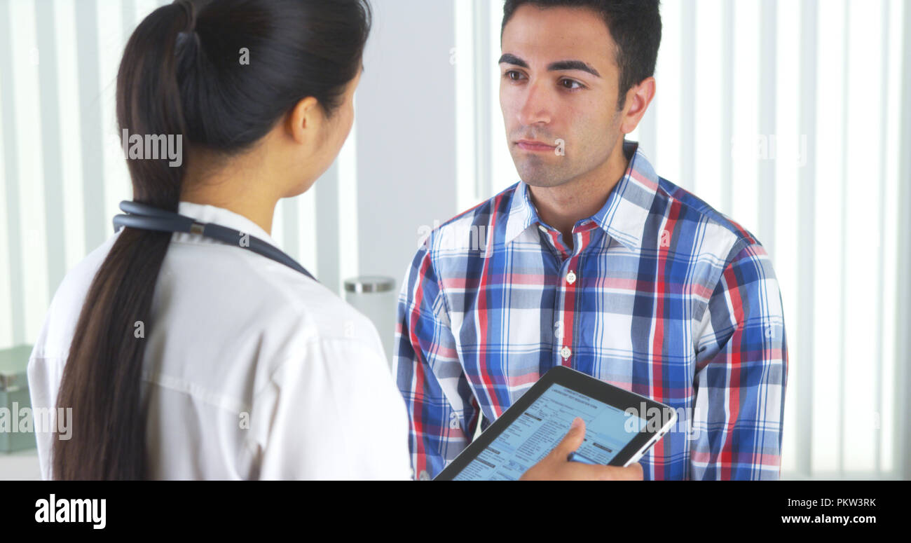 Chinese doctor talking to patient and taking notes Stock Photo - Alamy