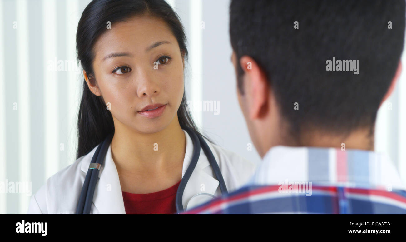 Chinese doctor talking to patient Stock Photo - Alamy