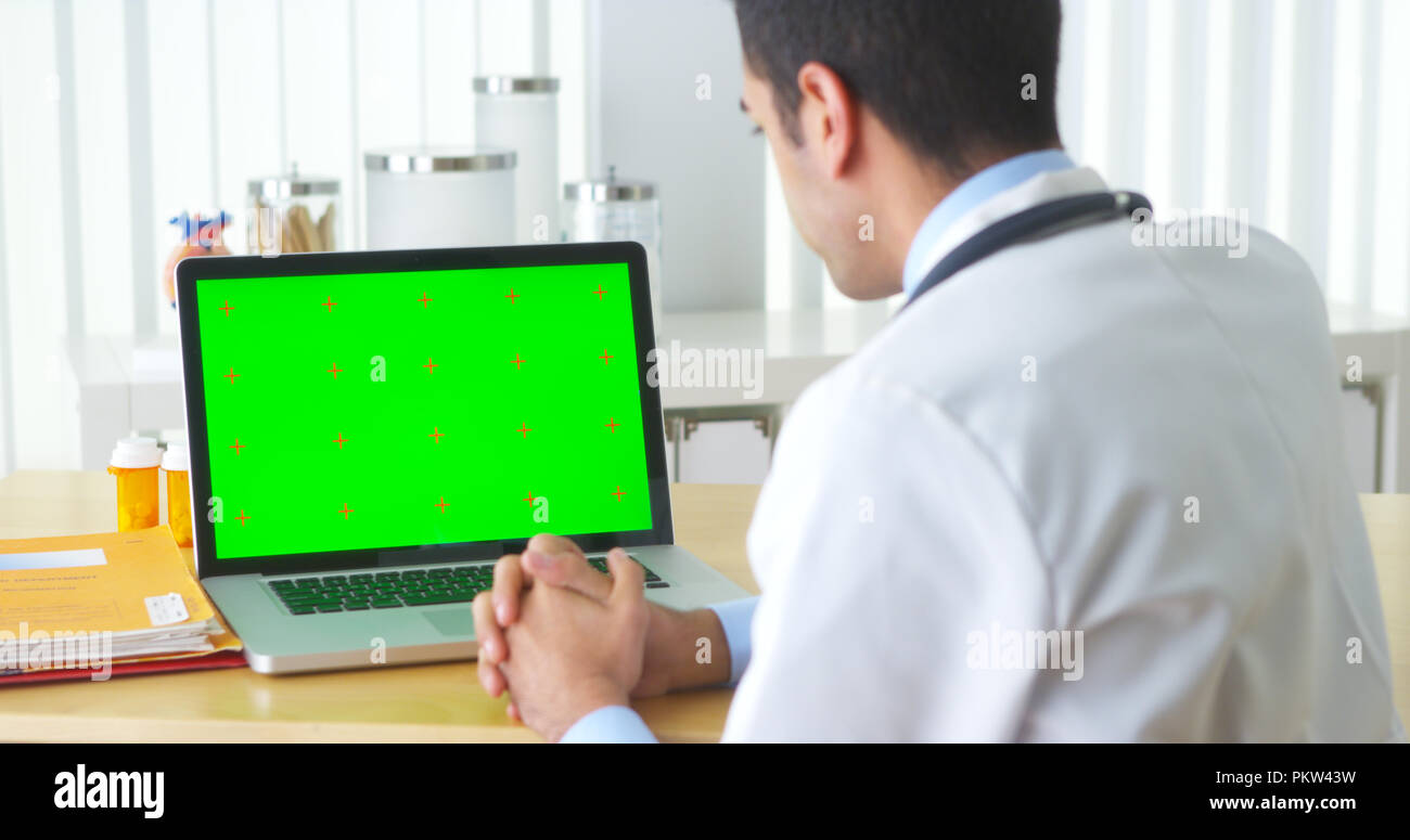 Mexican doctor talking to laptop with green screen Stock Photo - Alamy