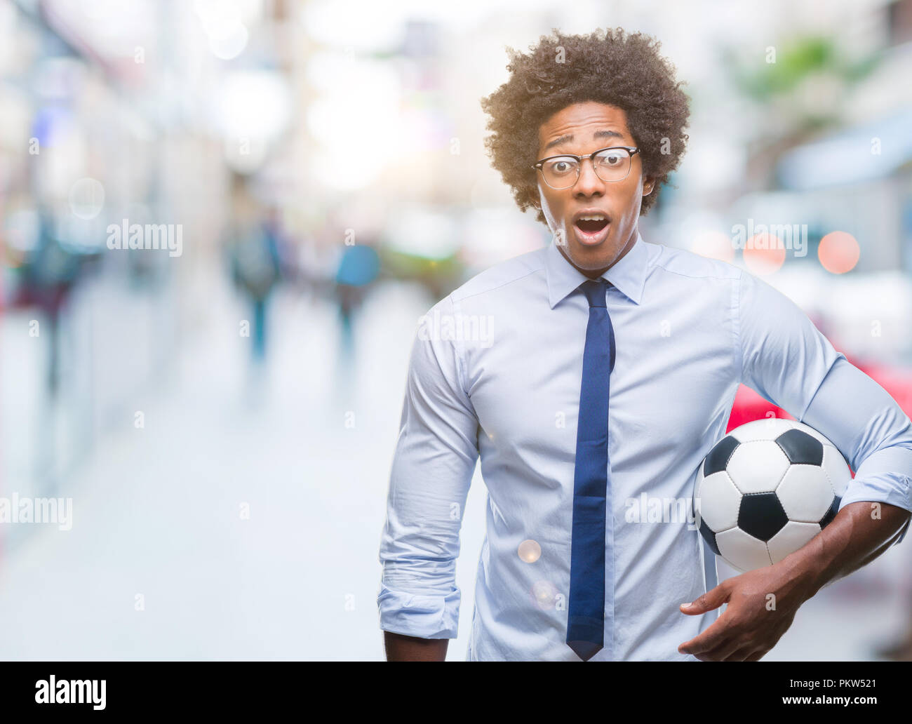 Afro american manager man holding soccer ball over isolated background ...