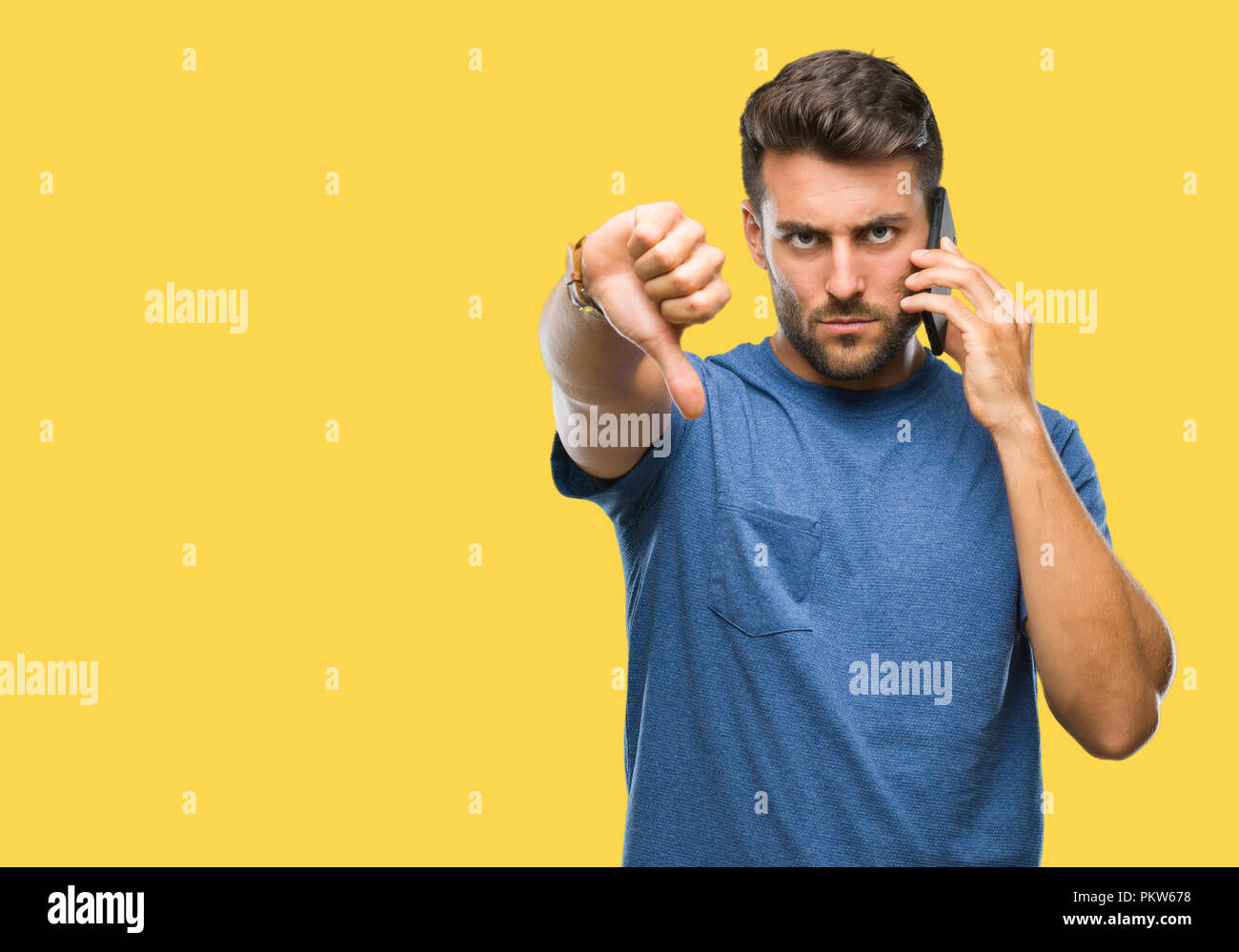 Young handsome man talking on smartphone over isolated background with ...