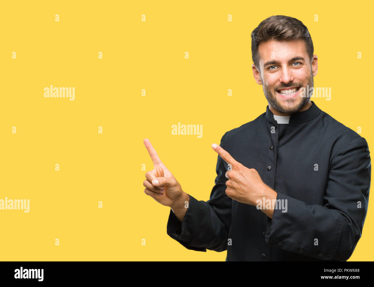 Young catholic christian priest man over isolated background smiling ...