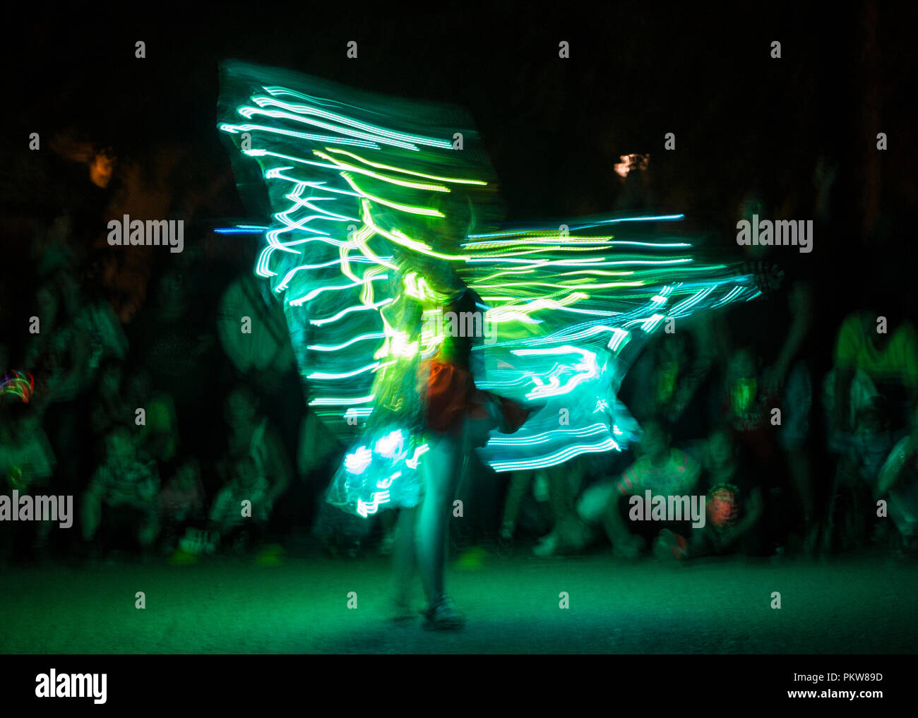 Long exposure photo with dancing girls dressed in led light costumes ...