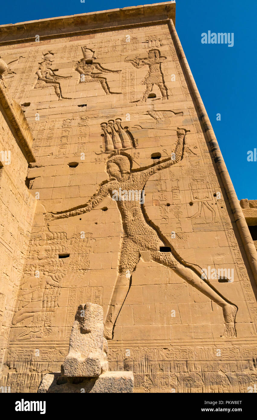 Outer pylon wall with carved Egyptian figures and hieroglyphs, Temple ...