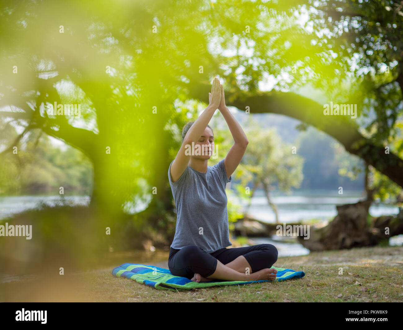 healthy woman relaxing while meditating and doing yoga exercise in the ...