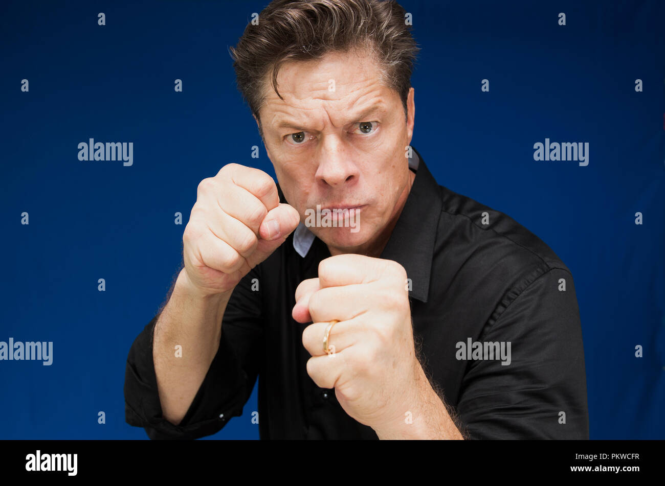 Aggressively man showing his fist Stock Photo - Alamy