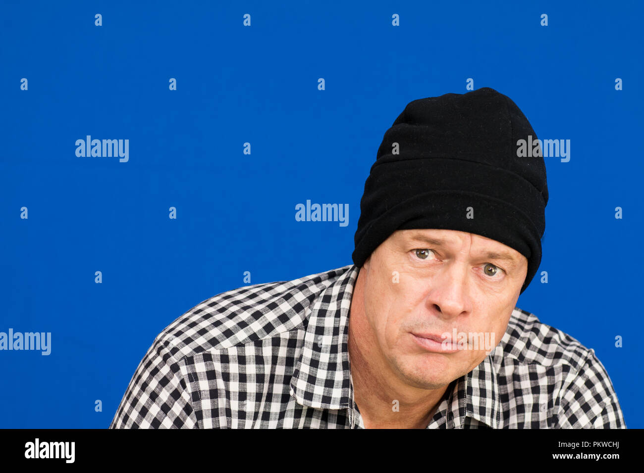 Brutal man is standing at slum. He is wearing plaid shirt Stock Photo ...