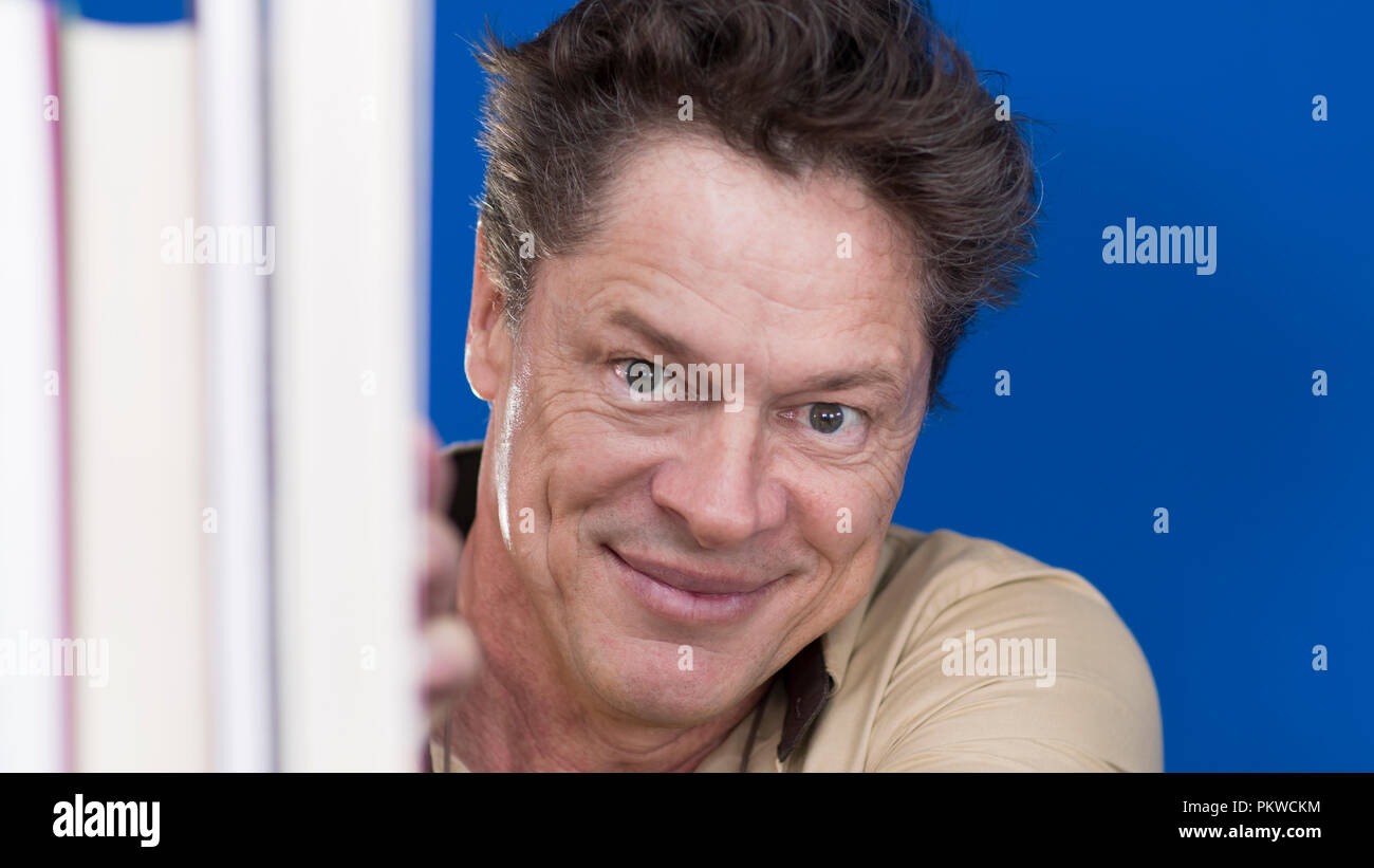 Very happy man with several books in hand. Glasses teacher, happy with ...