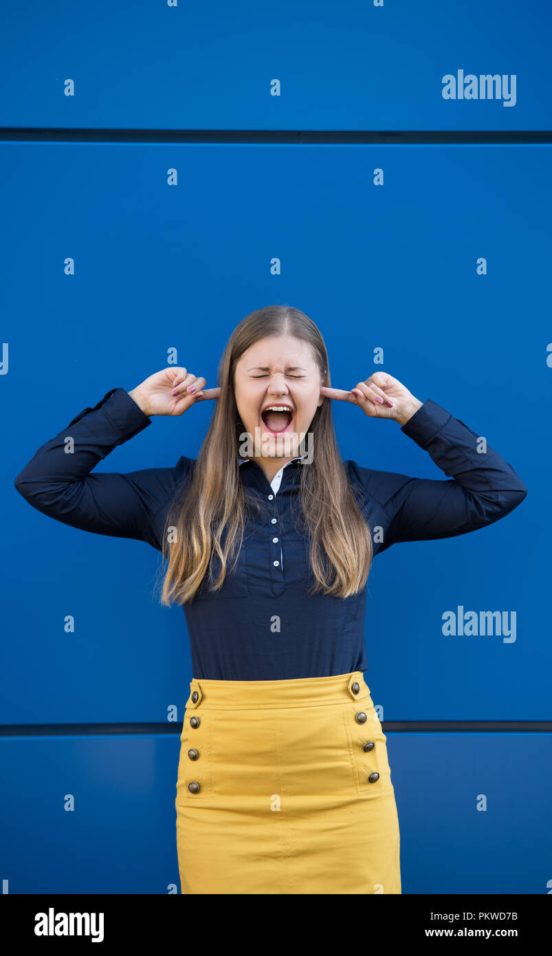 young business woman in front of blue office building, screaming Stock ...