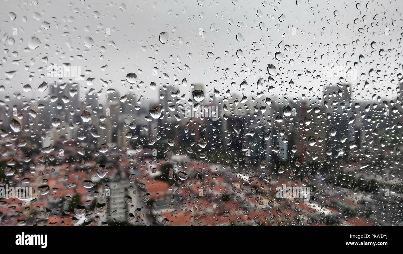 Rainwater drops on the window and on various background building ...