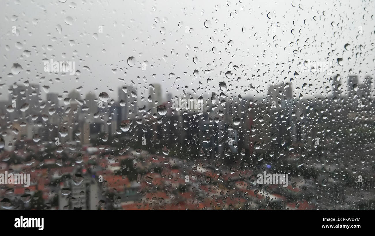 Rainwater drops on the window and on various background building ...