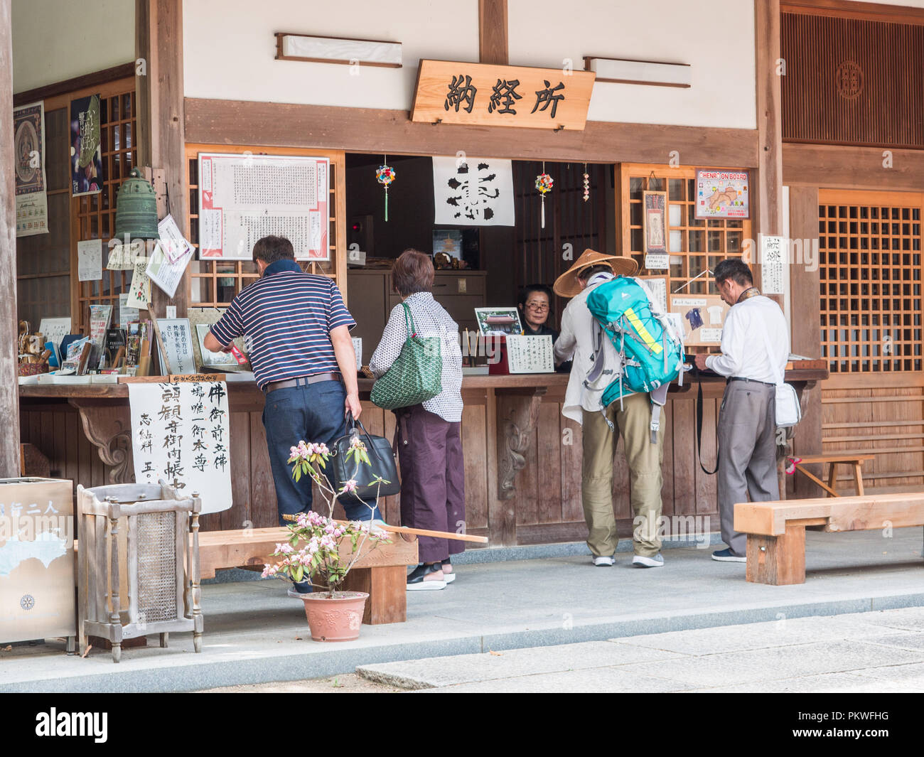 Henro pilgrim having pilgrimage book signed and stamped at temple ...