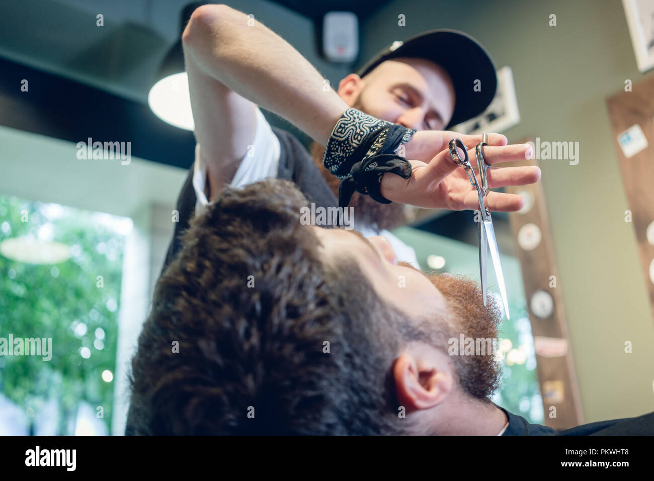 Close-up of the hand of a barber using scissors while trimming Stock ...