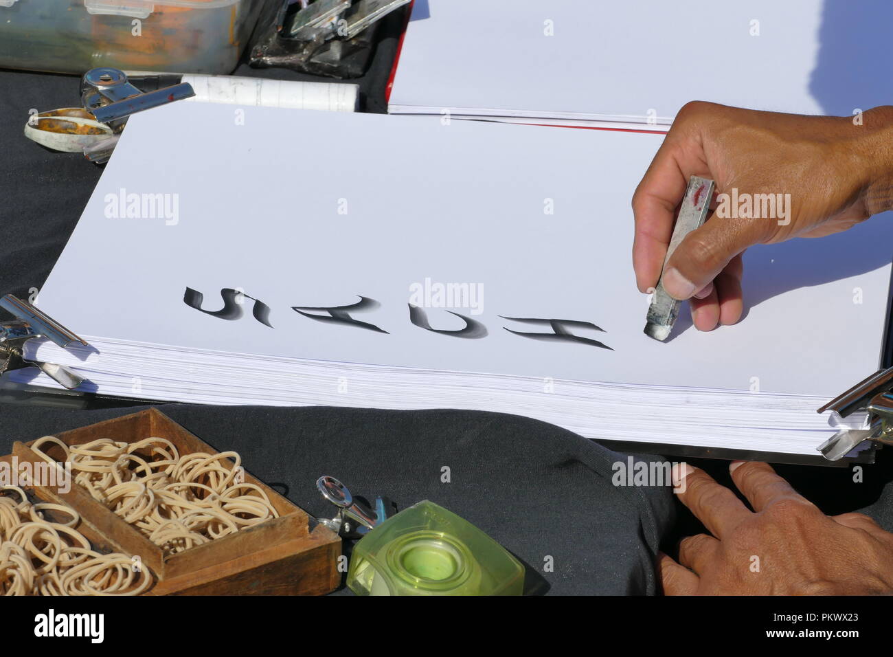 Street painter drawing christian name Stock Photo - Alamy