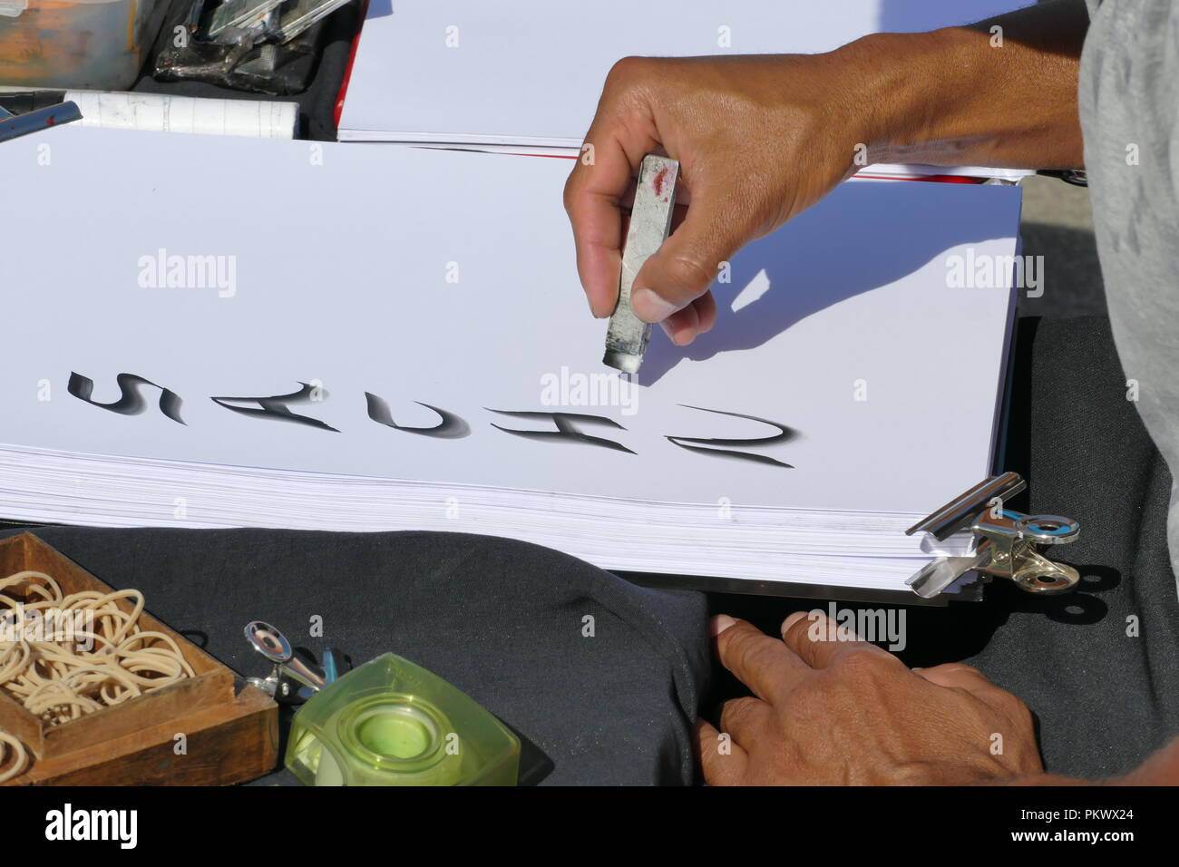 Street painter drawing christian name Stock Photo - Alamy