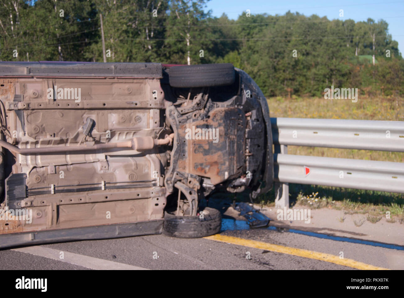 The inverted car after the accident lies on its side on the asphalt ...