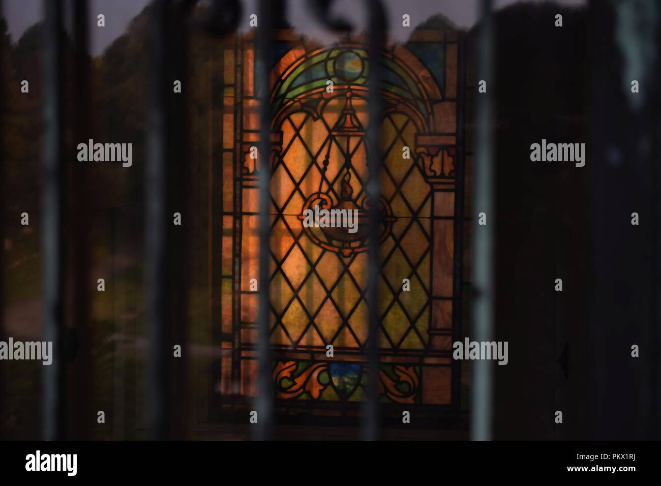 Fading sunlight seen through stained glass window in mausoleum Stock ...
