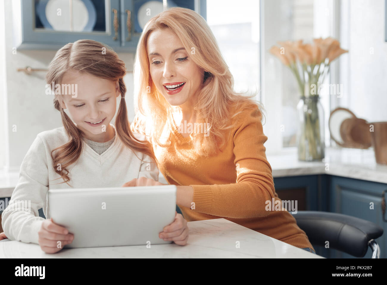 Delighted little girl staring at her tablet Stock Photo - Alamy
