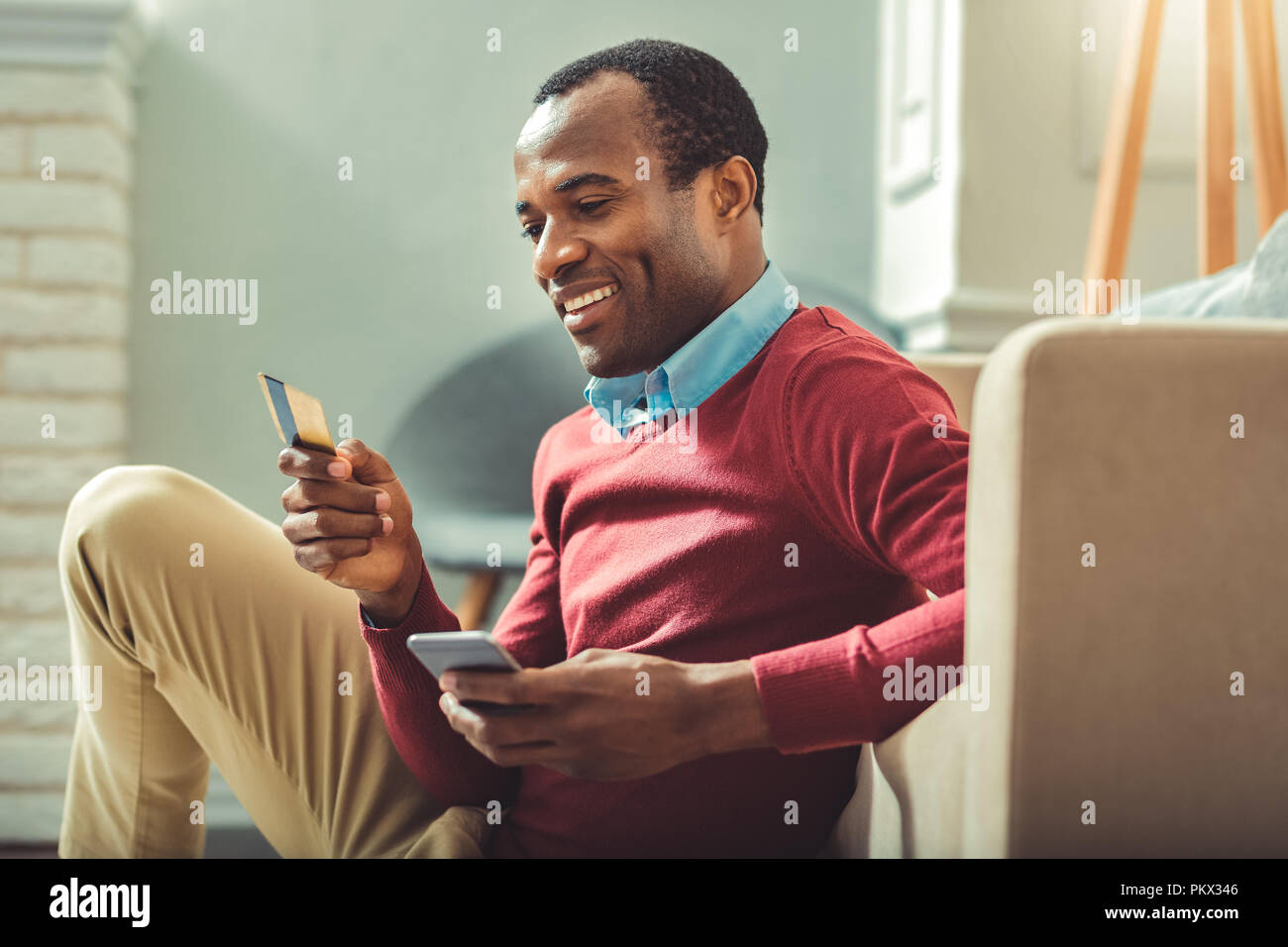 Happy afro american man entering card number Stock Photo - Alamy