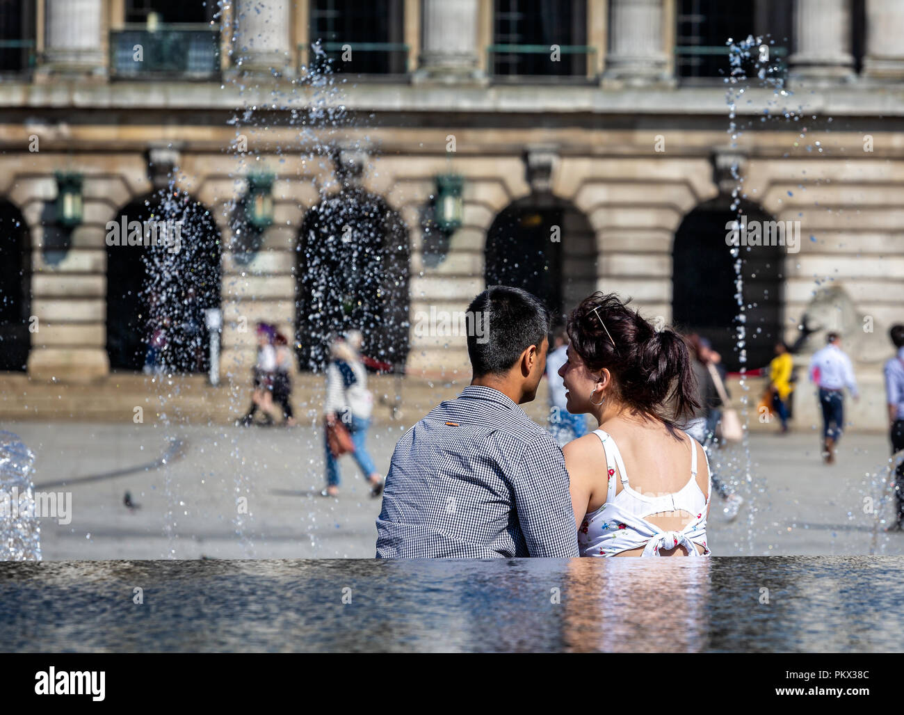A young couple talking amidst the fountains in the Old Market Square ...