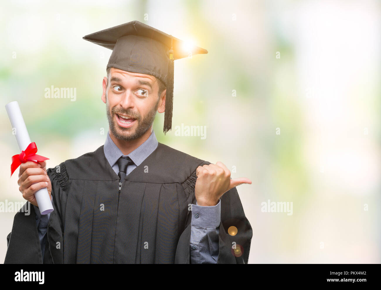 Young handsome graduated man holding degree over isolated background ...