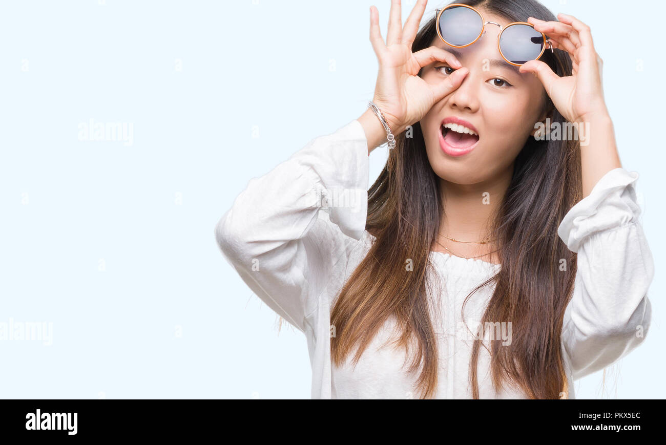 Young asian woman wearing sunglasses over isolated background doing ok ...