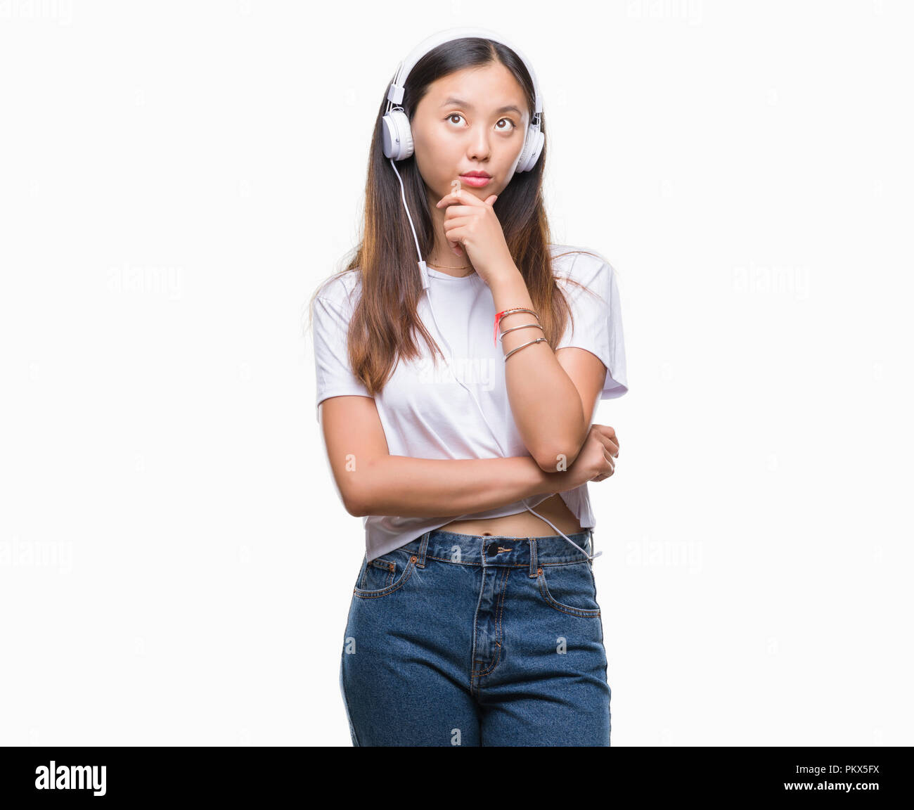 Young asian woman listening to music wearing headphones isolated ...