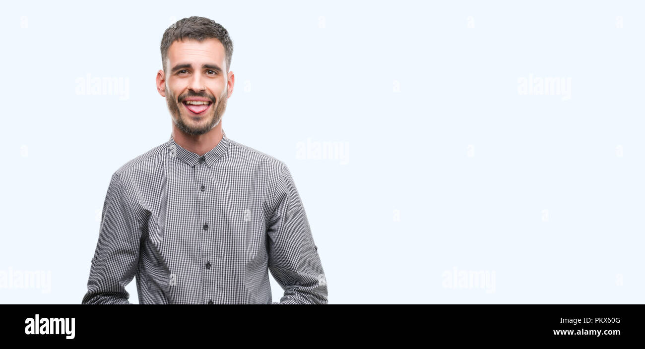 Young hipster man sticking tongue out happy with funny expression ...
