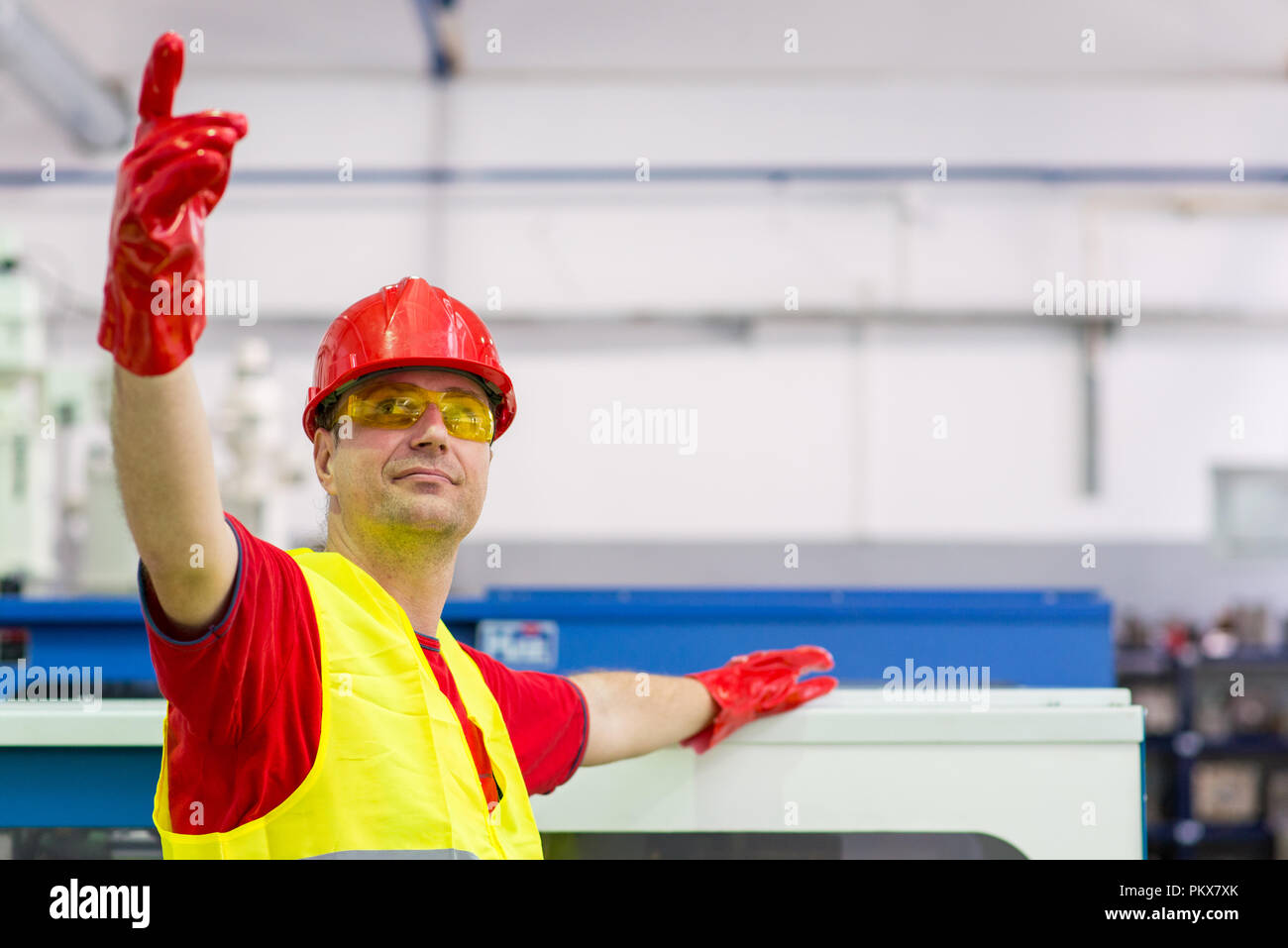 Factory engineer with red protective gloves in yellow reflective west ...