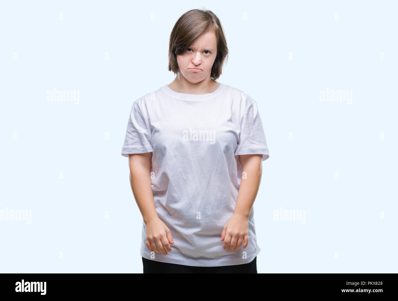 Young adult woman with down syndrome over isolated background depressed ...