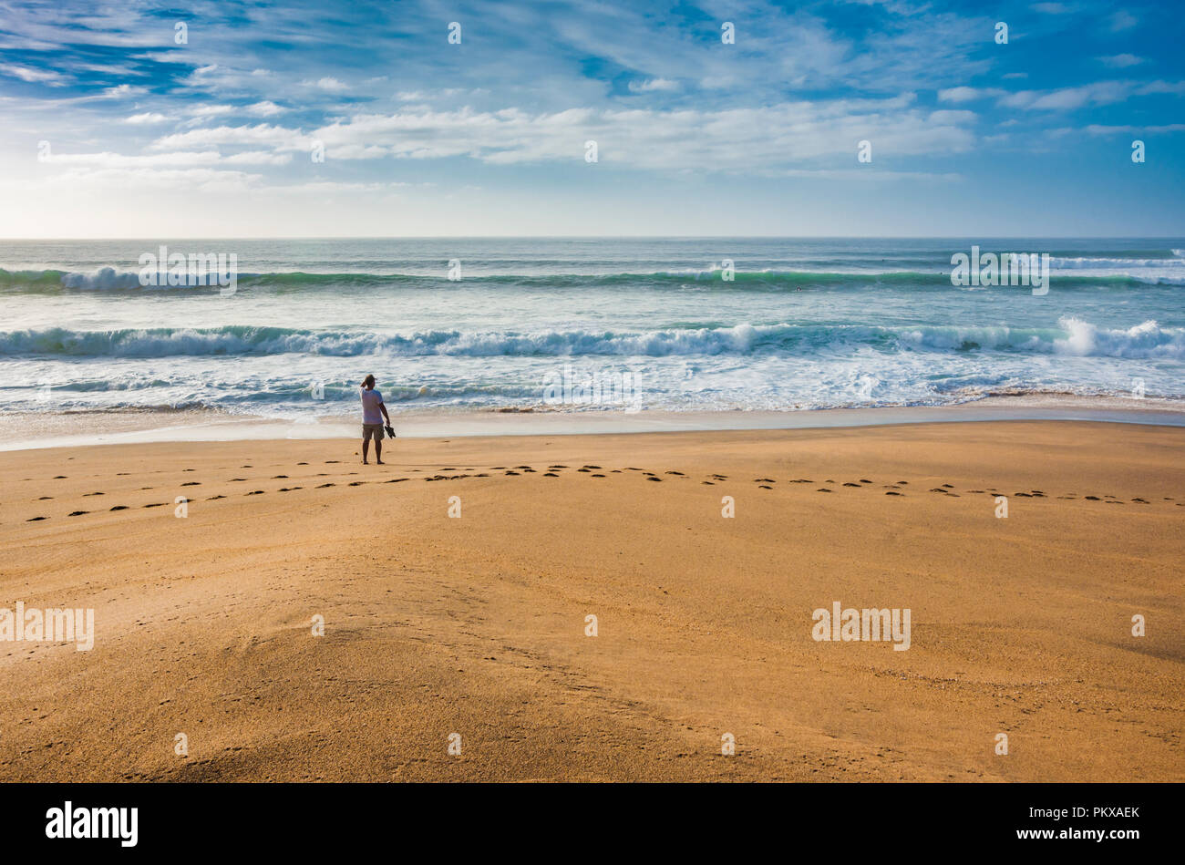Man standing on beach looking out to sea Stock Photo - Alamy