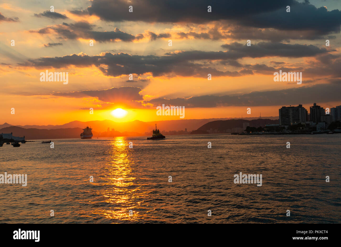 Cargo ship leaving the harbor, sailing out to sea with a beautiful ...